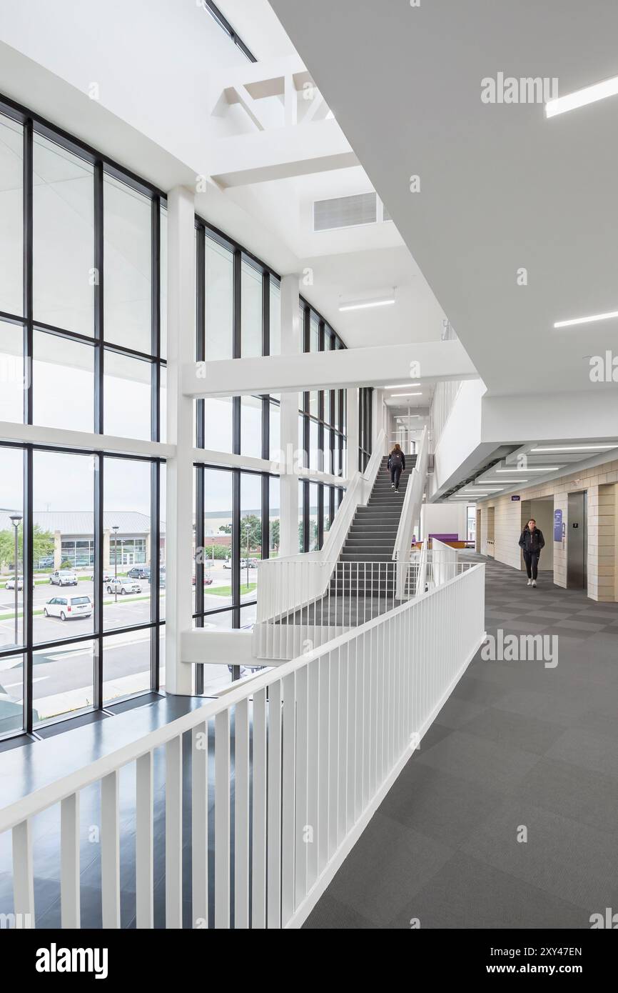 Hallway and stairs open to atrium with wall of windows in new ...