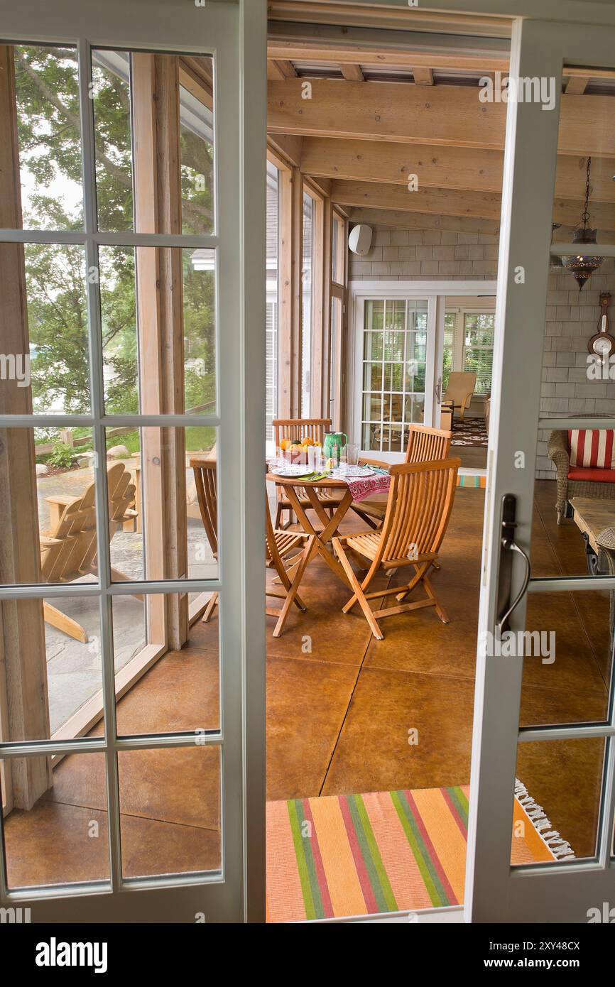 Looking through sliding doors into breezeway with table set and view to ...