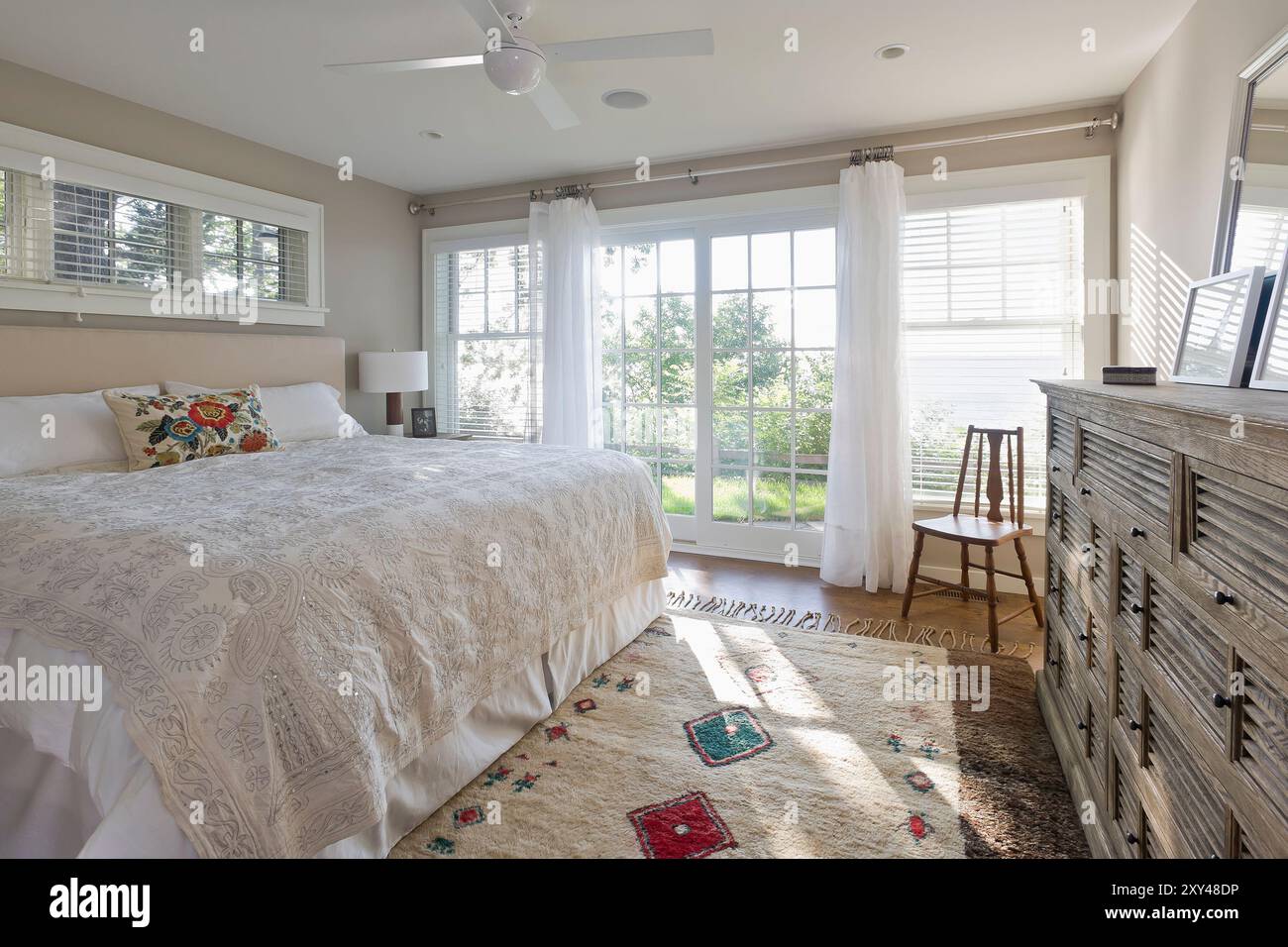 Sparkling sunshine enters master bedroom of cottage with nice handmade ...