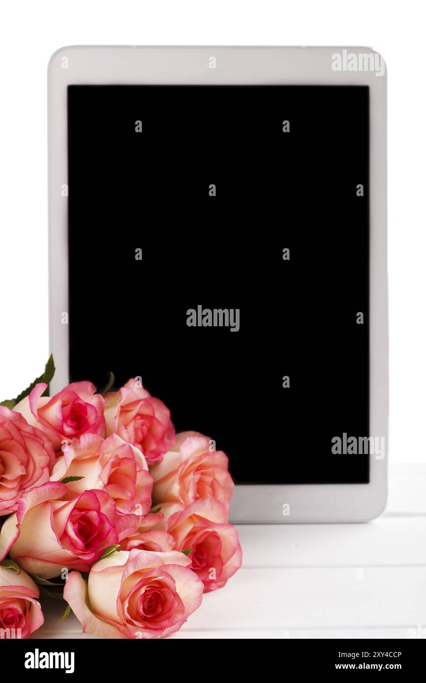 Tablet and bouquet of pink roses on white background. Space for text ...