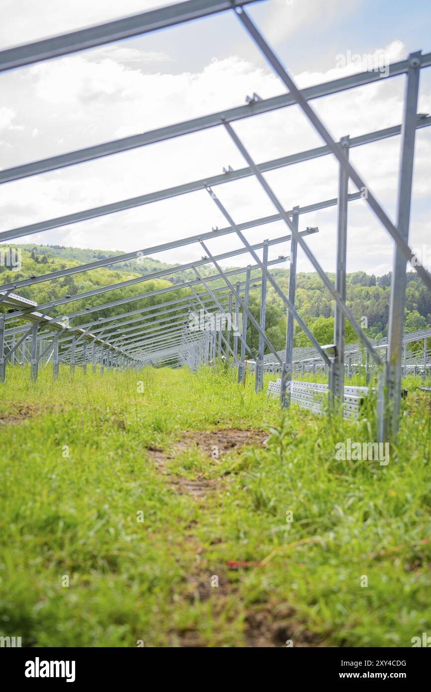 Metal structures for solar systems on green meadows under a cloudy sky ...