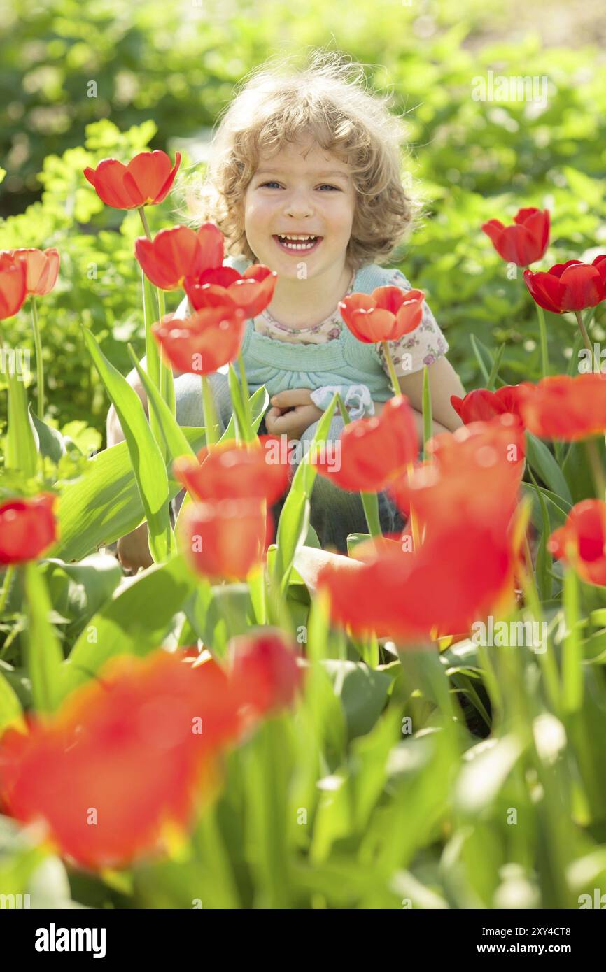 Happy child against spring flowers background Stock Photo - Alamy