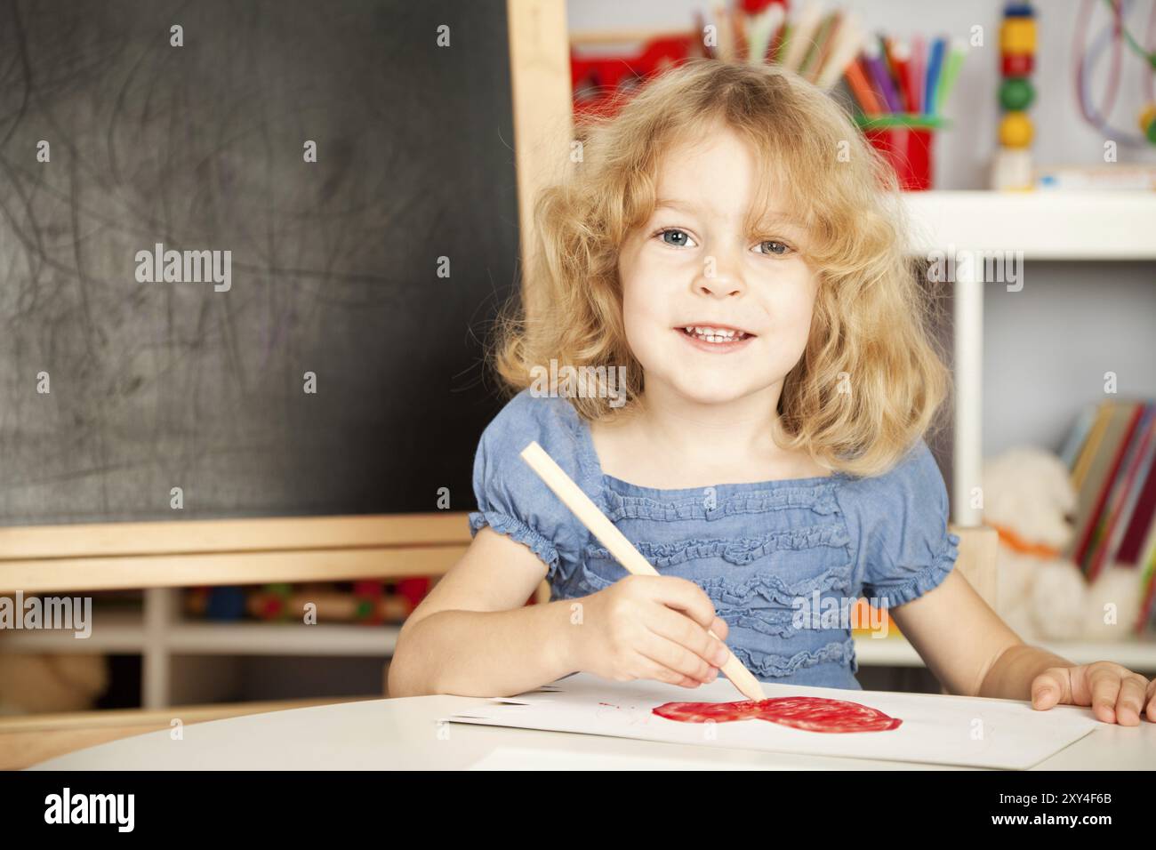 Happy child painting heart on a paper in class. School concept Stock ...