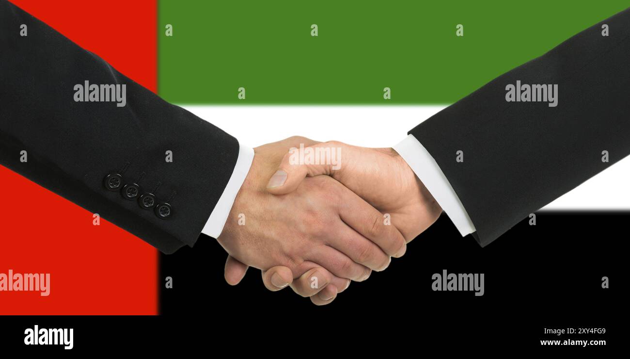 The United Arab Emirates flag and business handshake Stock Photo - Alamy