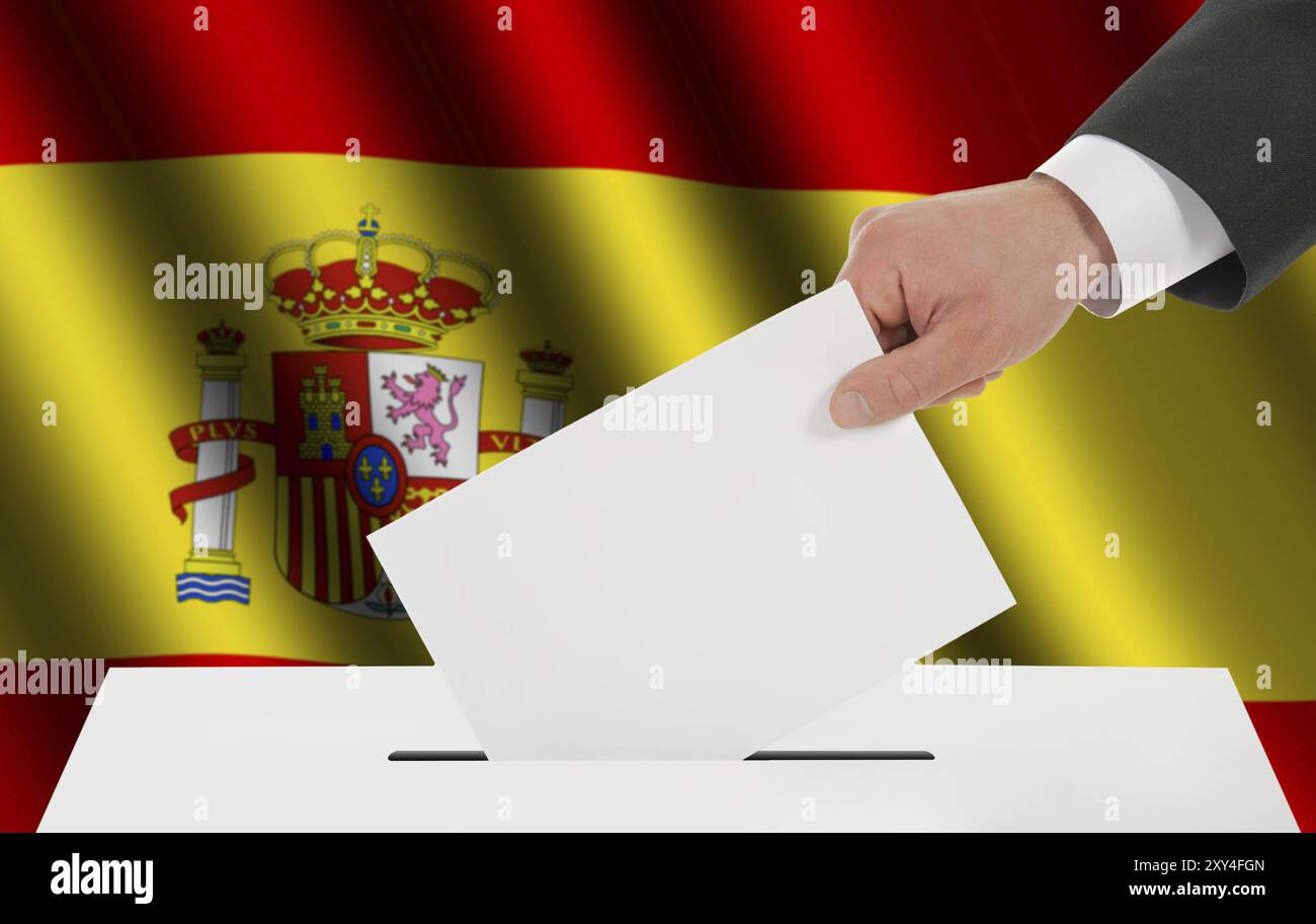 The Spanish flag and the hand with the bulletin about the ballot box ...
