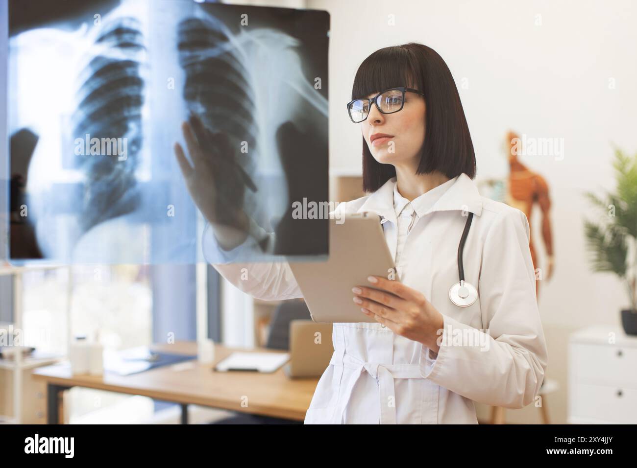 Female doctor studies x-rays of patient on glass board Stock Photo - Alamy