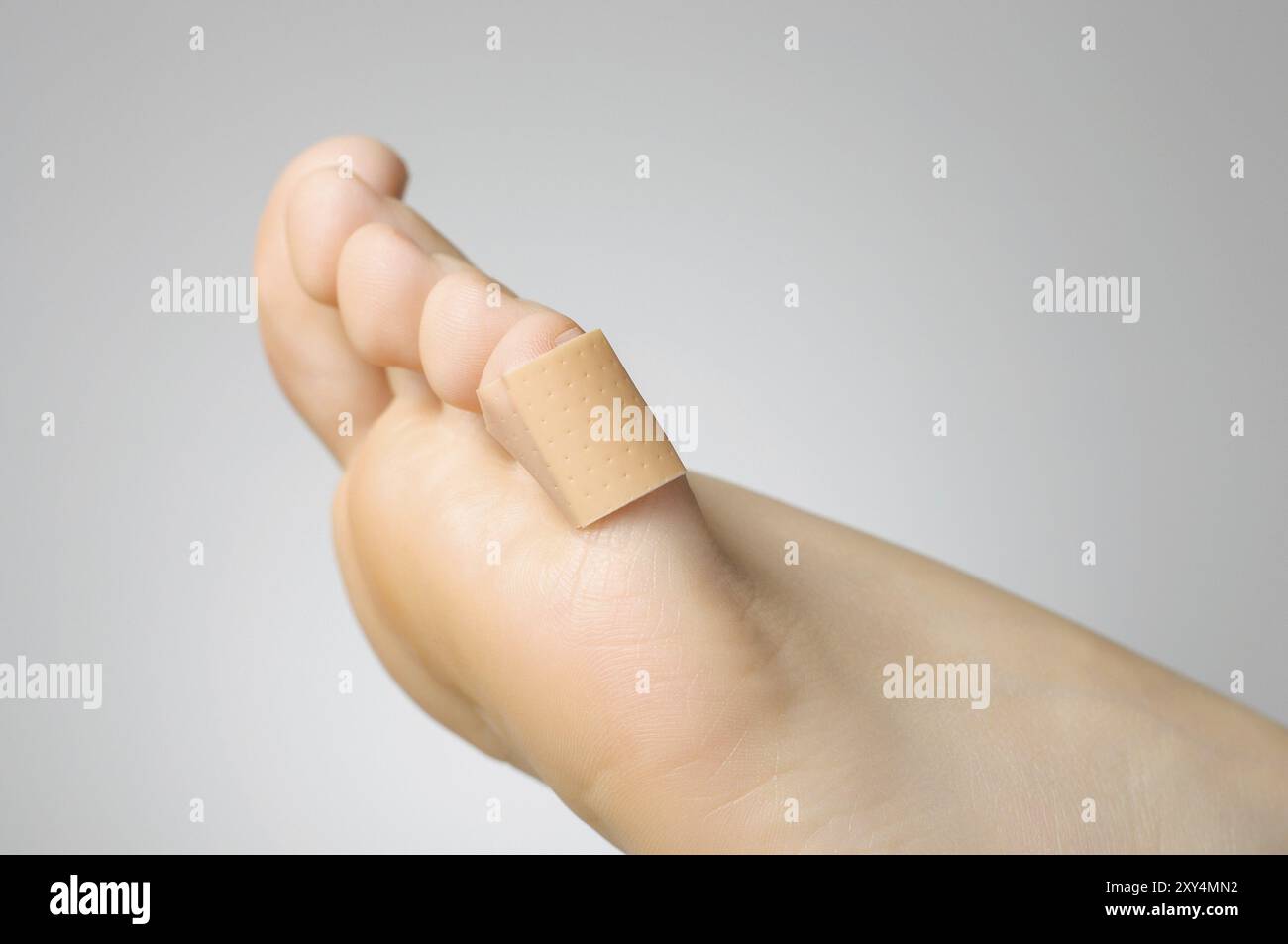 Injured female toe with adhesive bandage Stock Photo - Alamy