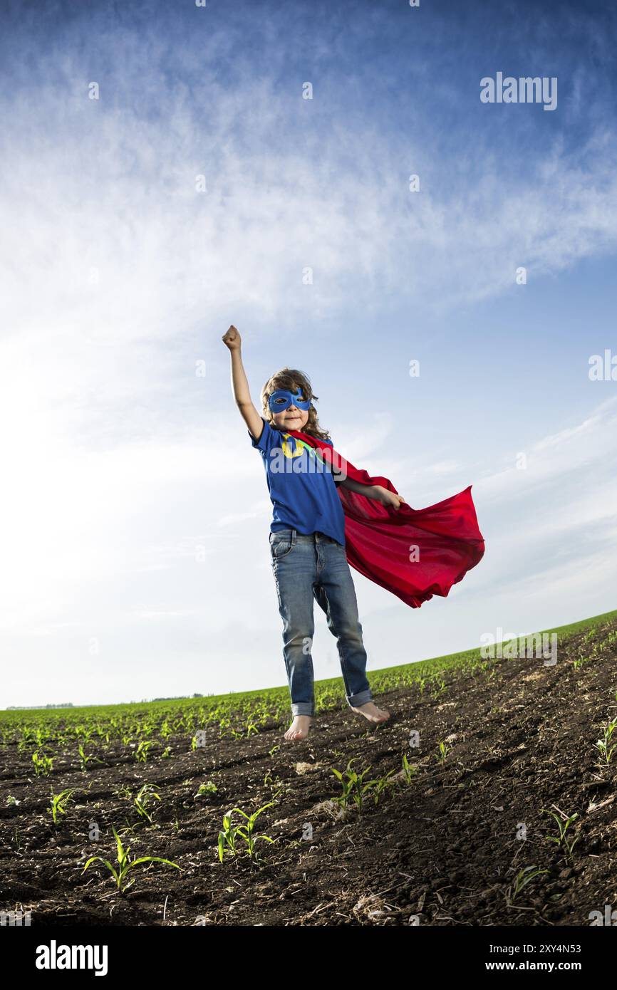 Superhero kid jumping against dramatic blue sky background Stock Photo ...
