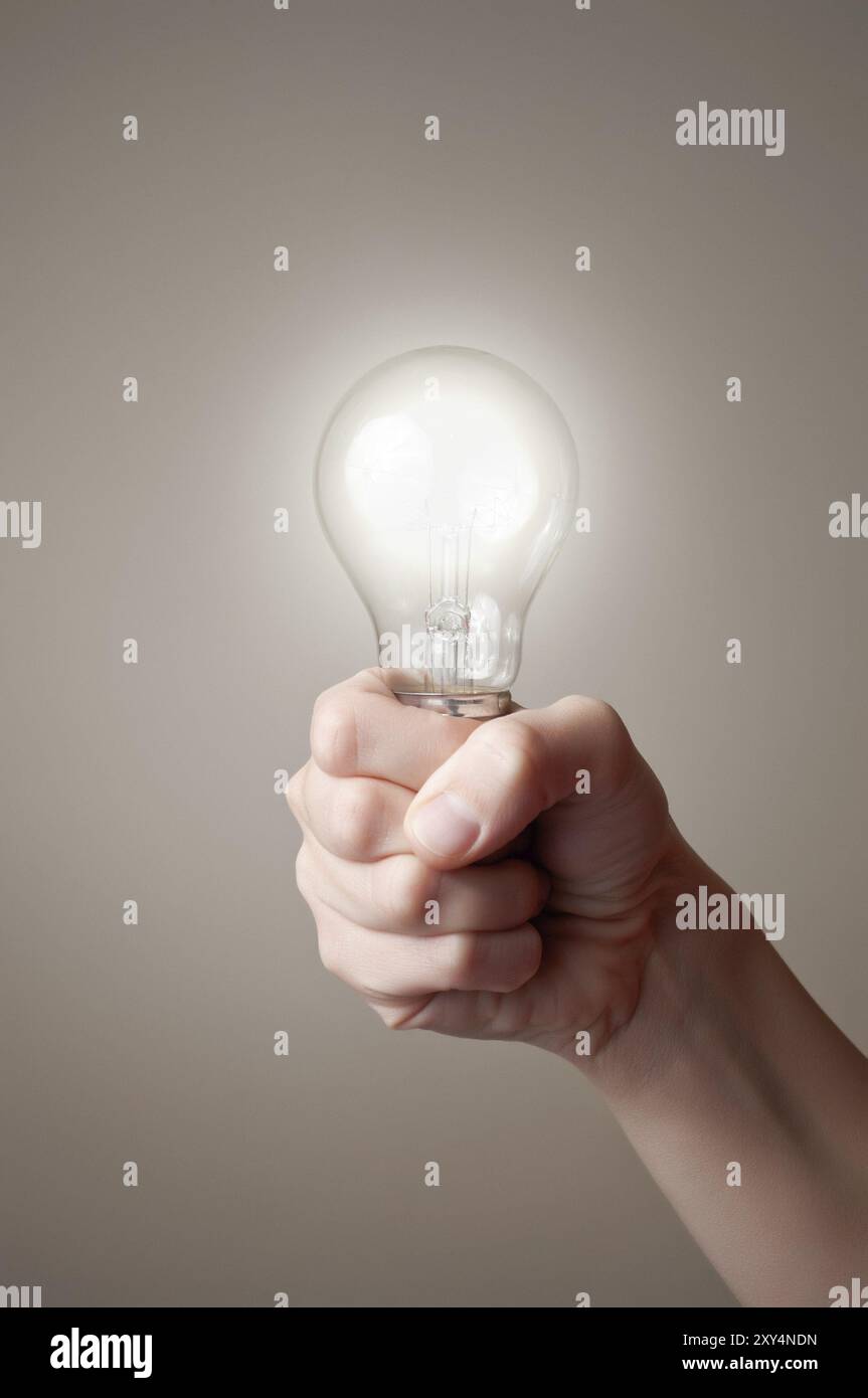Hand holding a glowing light bulb Stock Photo - Alamy