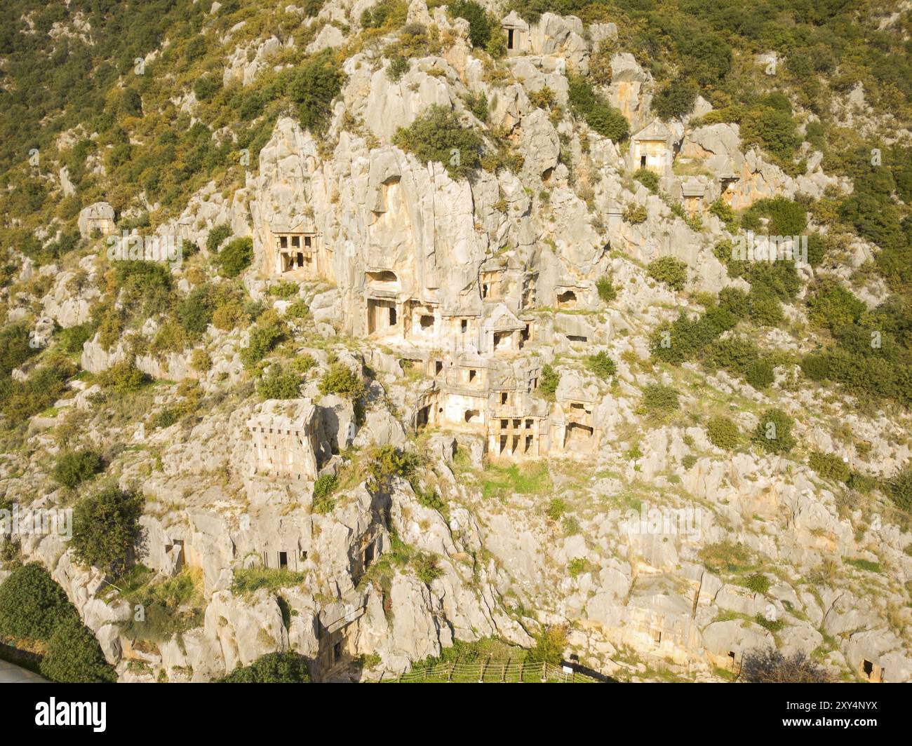 High angle drone aerial view of rock cut tombs carved into cliffside in ...