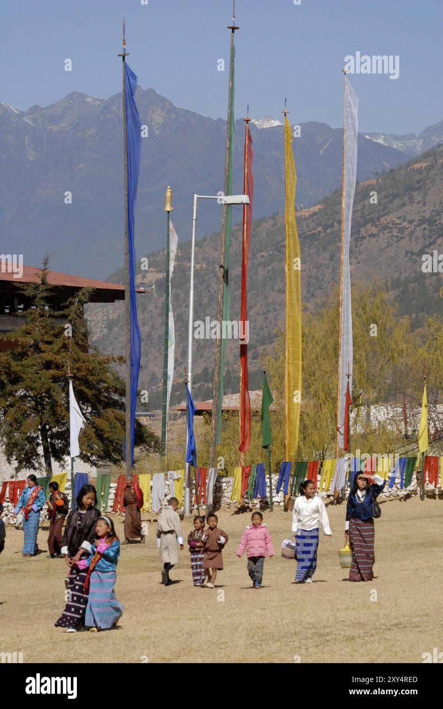 People arriving at the Paro Festival (Paro Tsechu), with prayer flags ...