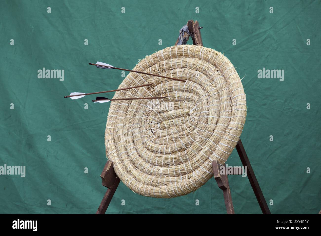 Traditional archery round coiled straw target on a stand with three ...