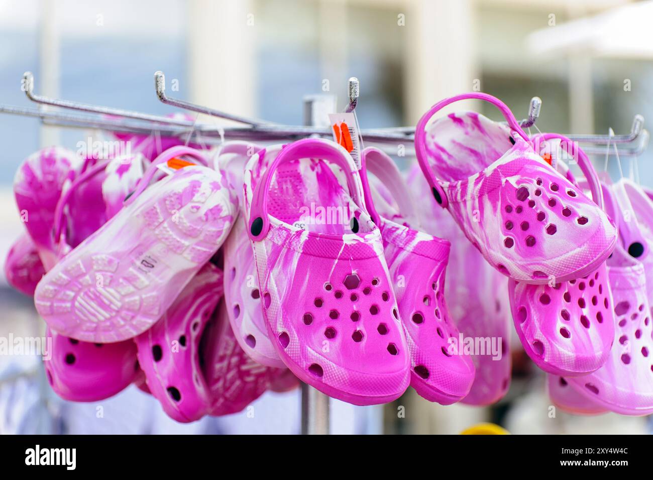 Pink-coloured flip-flops on a stand in front of a shoe shop Stock Photo ...