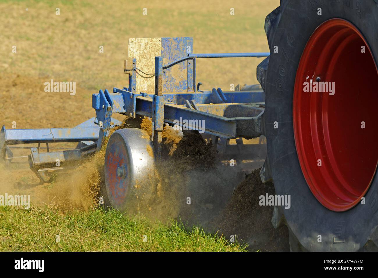 Tractor pulls a cultivator behind it Stock Photo - Alamy
