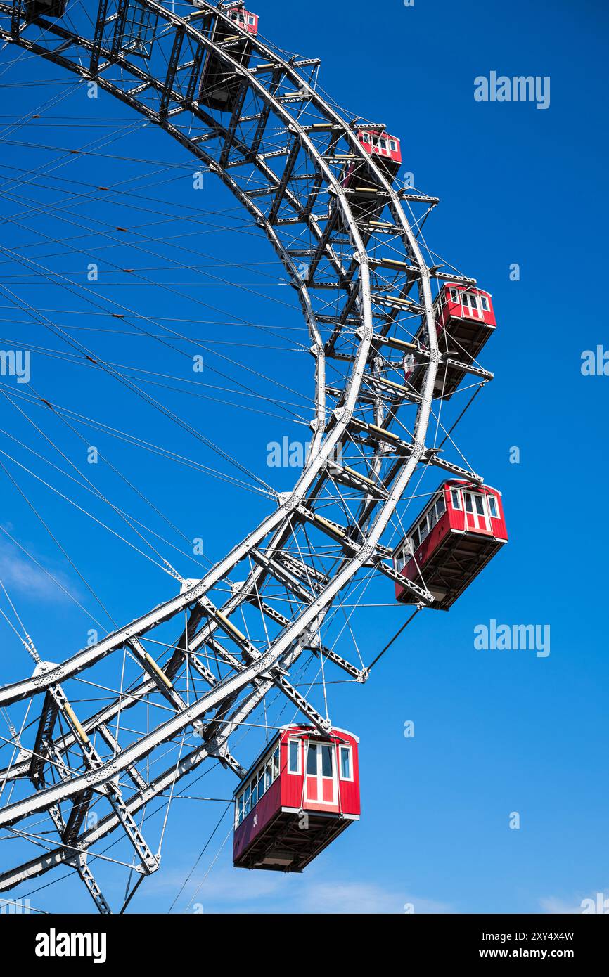 Red gondolas on the Ferris wheel in the Prater of Vienna under a blue ...