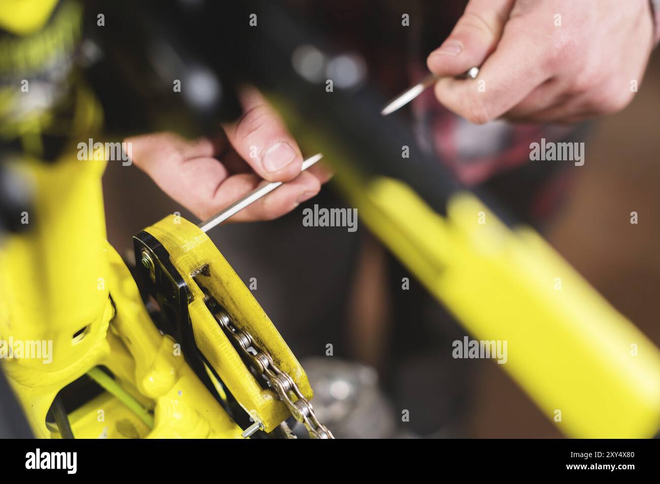 Close-up maintenance of a mountain bike. Male hands adjust the chain ...