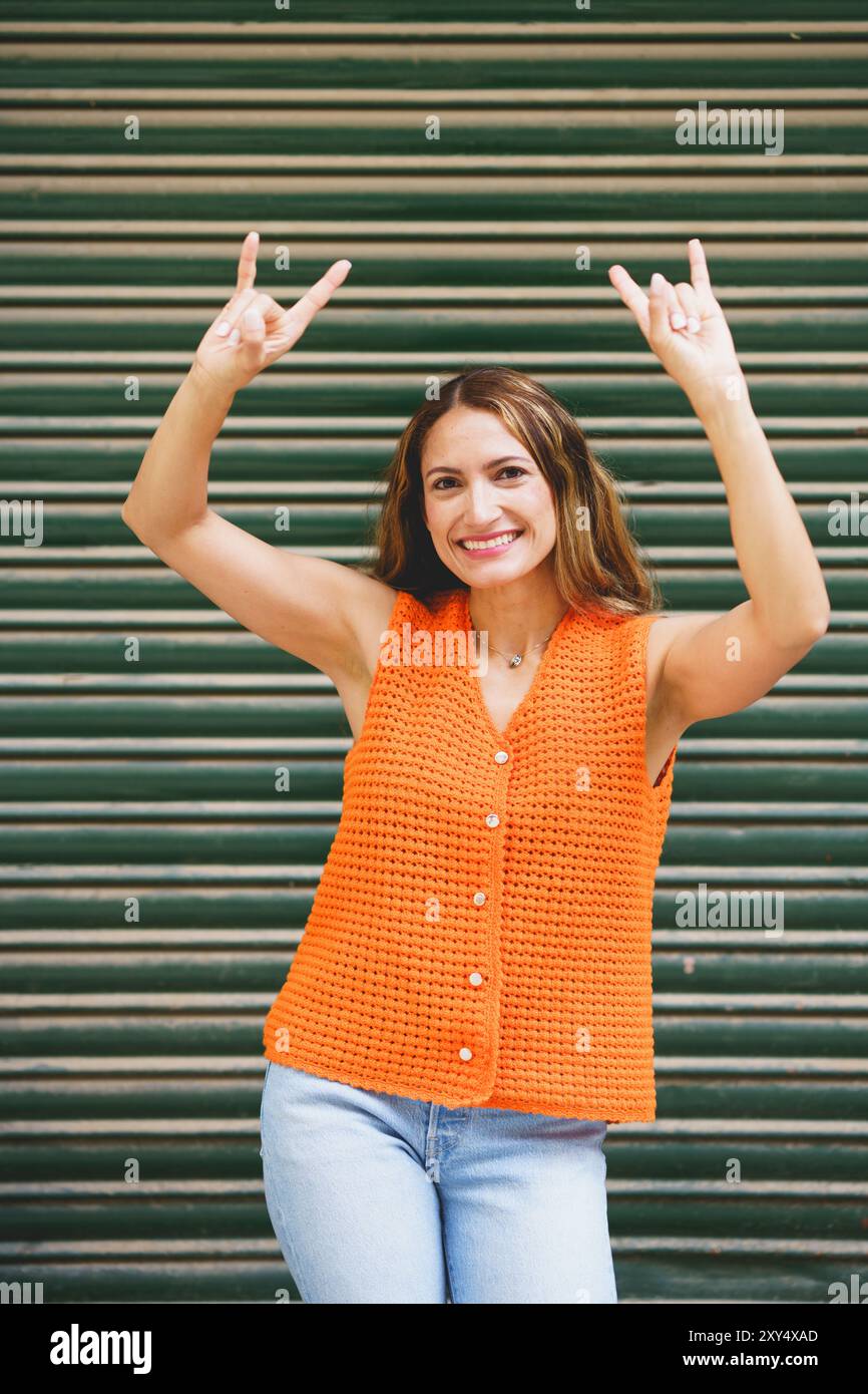 Latin woman smiling doing the heavy metal horns hand sign Stock Photo ...