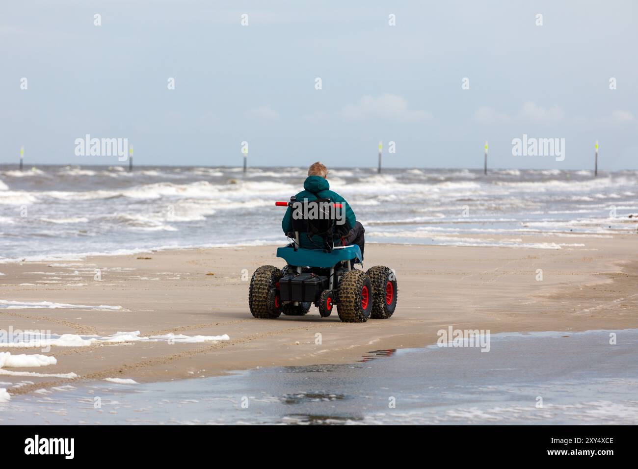 Man with handicap on the beach with a beach wheelchair Stock Photo - Alamy