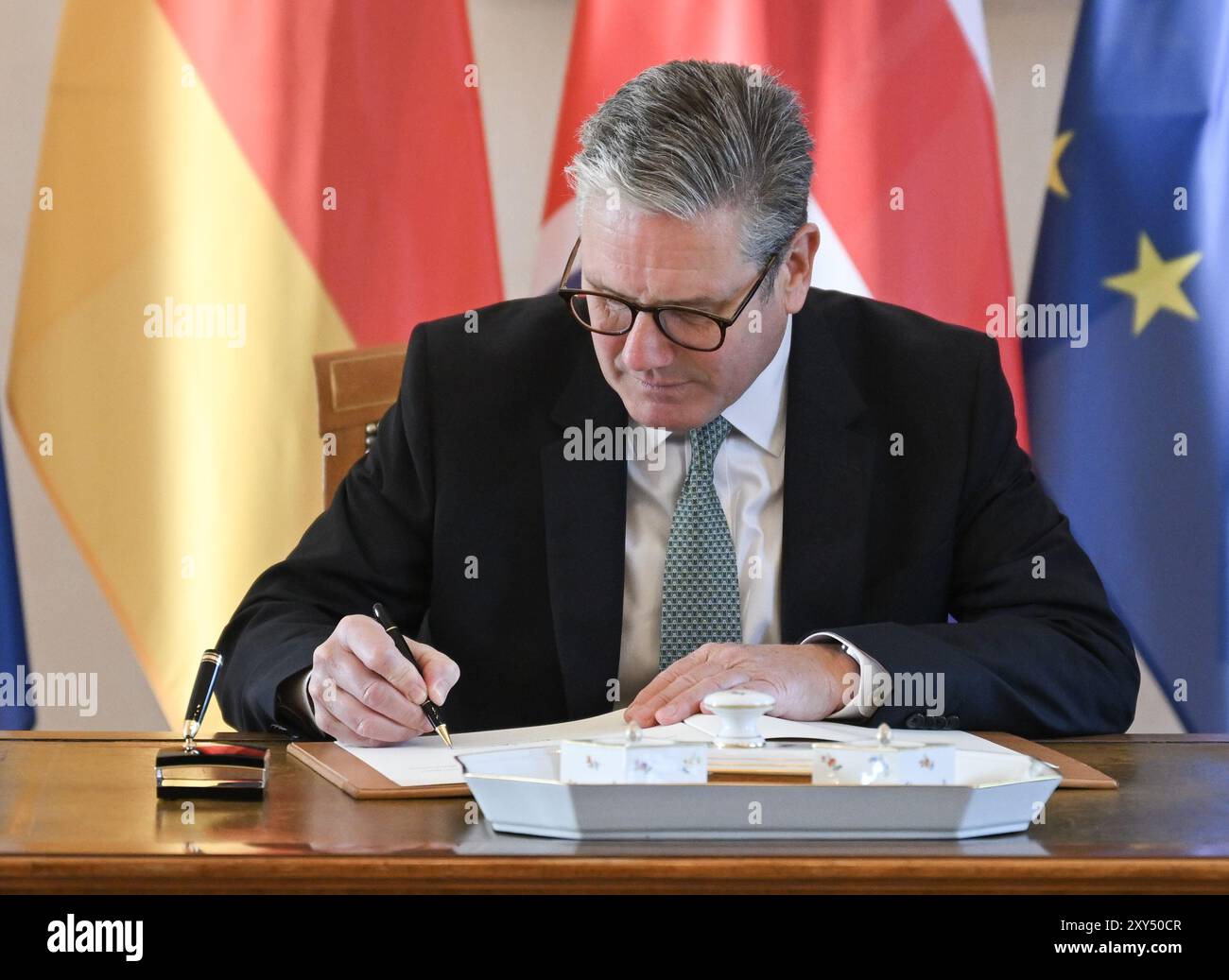 Prime Minister Keir Starmer signs a guest book at Bellevue Palace in ...