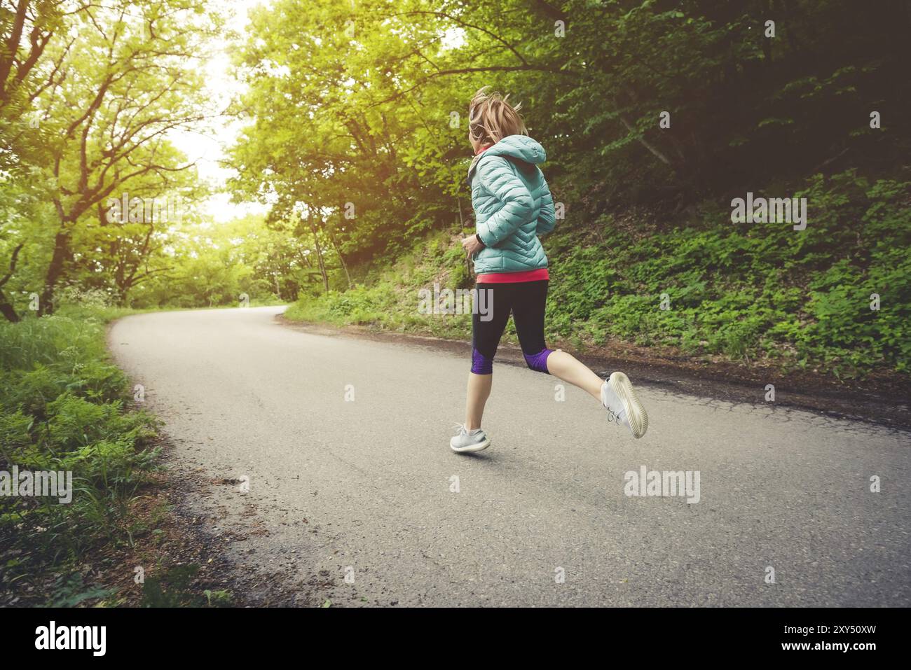 Young fitness blonde woman in headphones running at morning caucasian ...