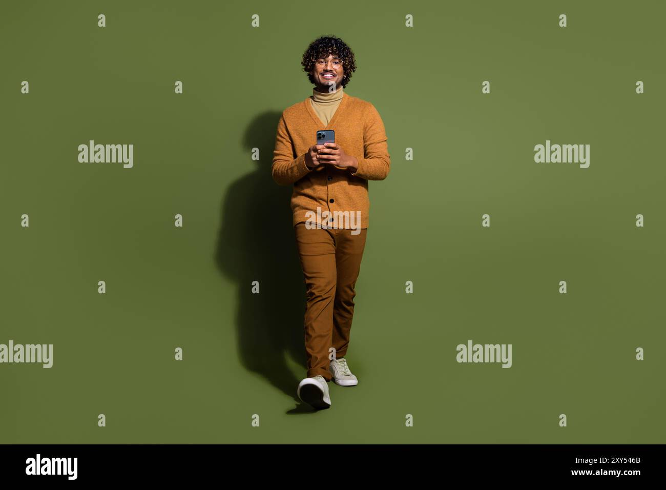 Full body photo of attractive young man walk hold telephone dressed ...