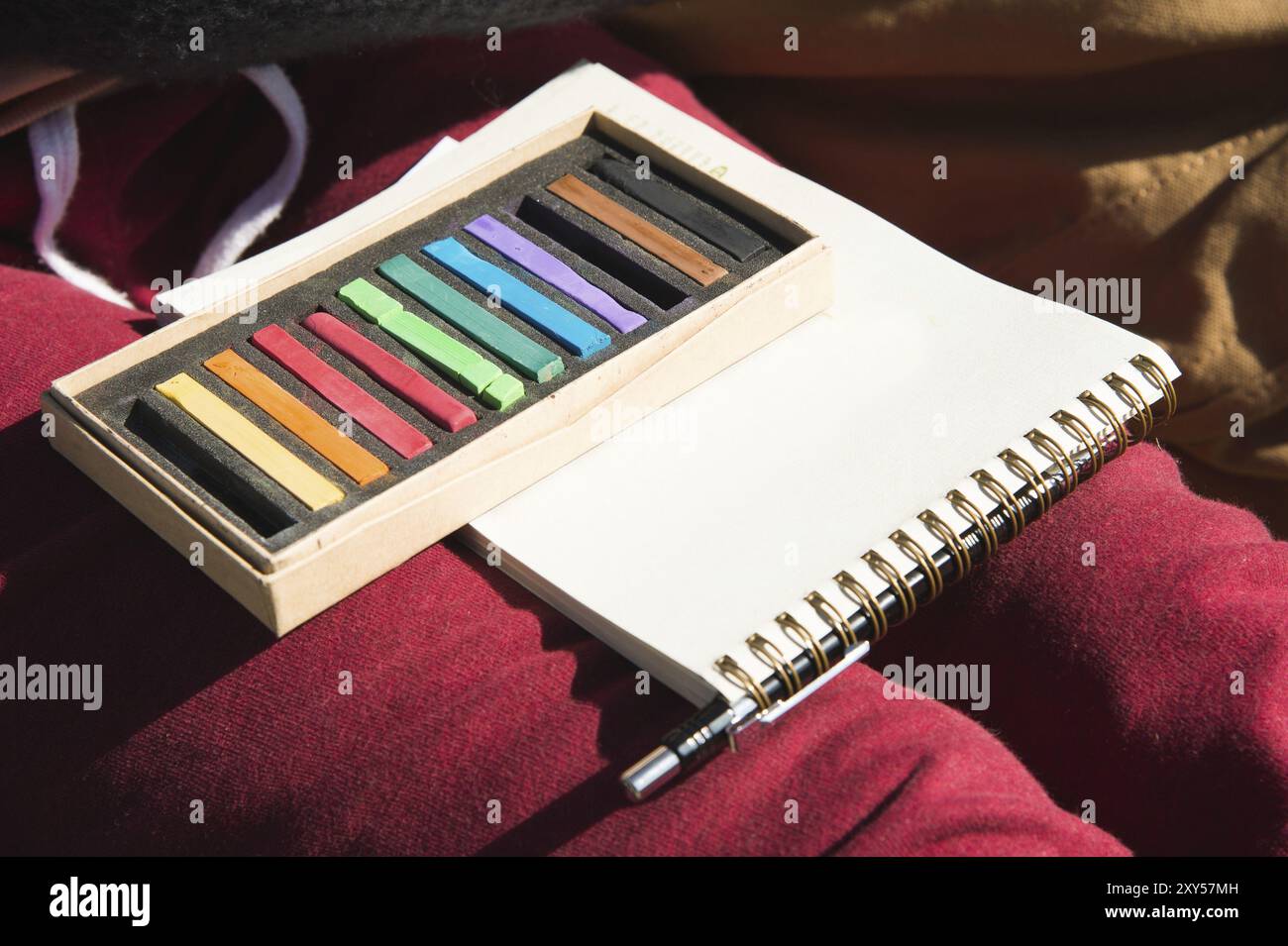 A close-up on the girl's legs is a notebook with a pencil and a set of ...