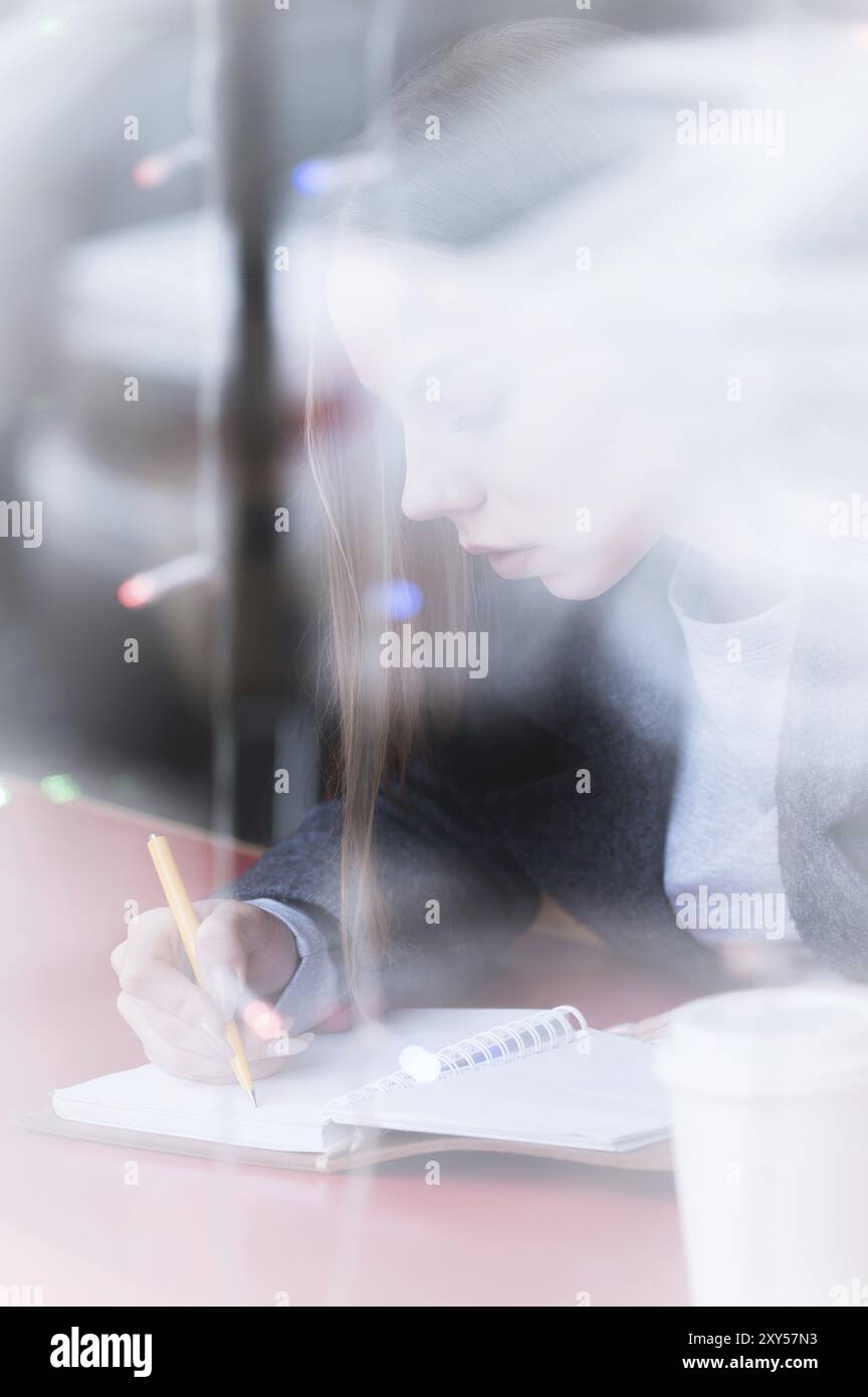 Portrait of an attractive young journalist girl with pen and notepad in ...