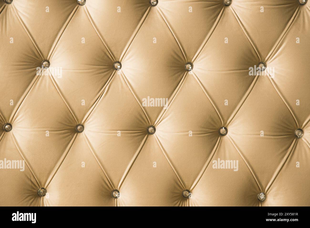 Beige soft textile background with symmetrical buttons on the corners ...