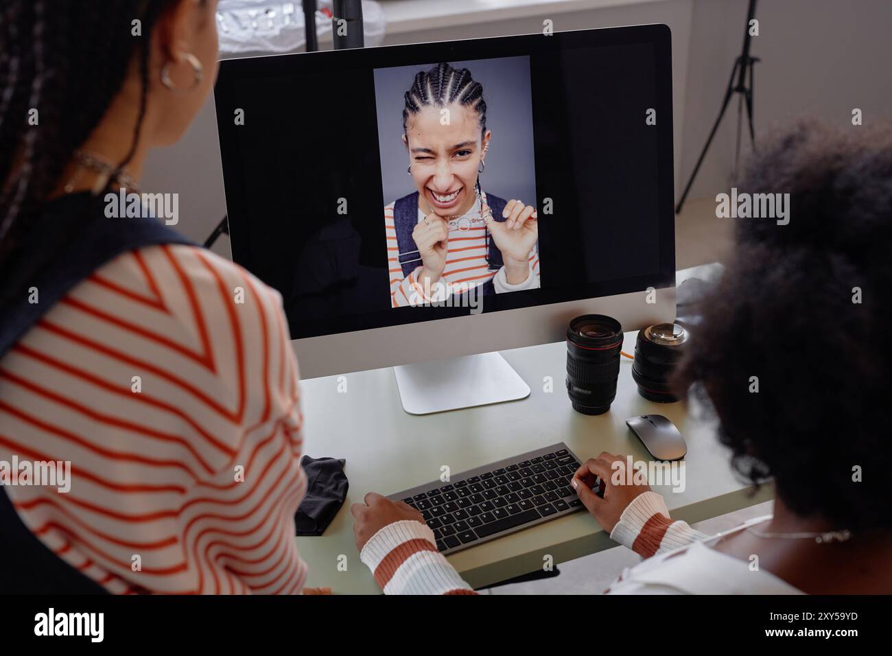 Over shoulder view at two women looking at portrait pictures on ...
