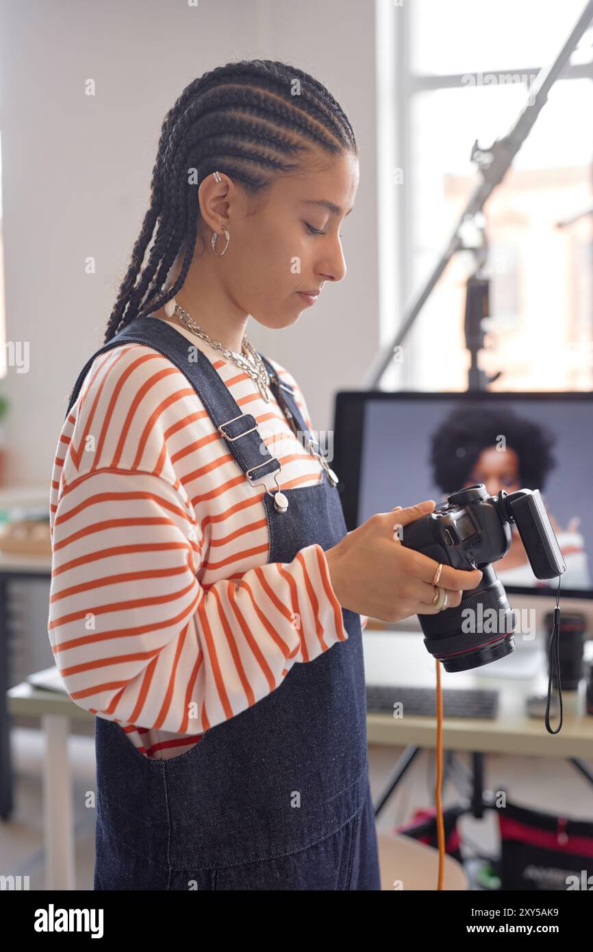 Vertical side view portrait of gen Z young woman looking at in camera ...