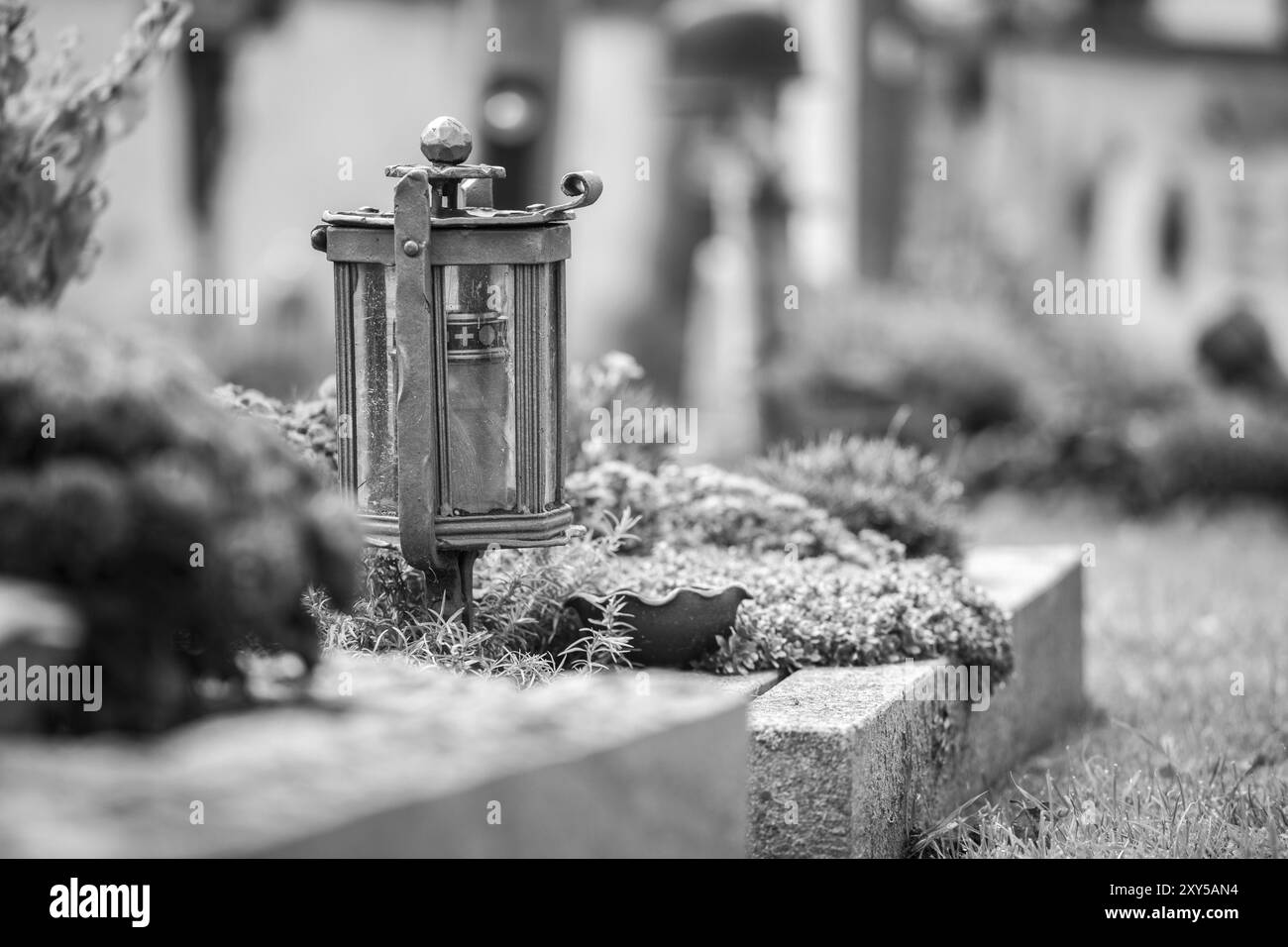 Candle in an iron lantern on a grave at a cemetery Stock Photo - Alamy