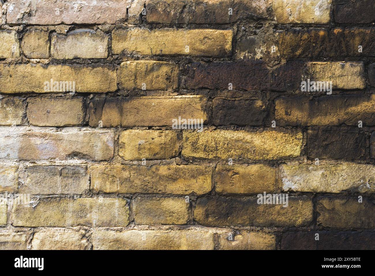 Textured background of old faded bricks stained with black oil. A brick ...