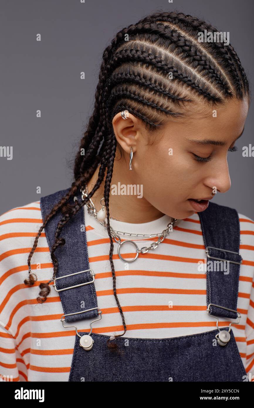 Minimal portrait of gen Z young woman with cornrows hairstyle looking ...