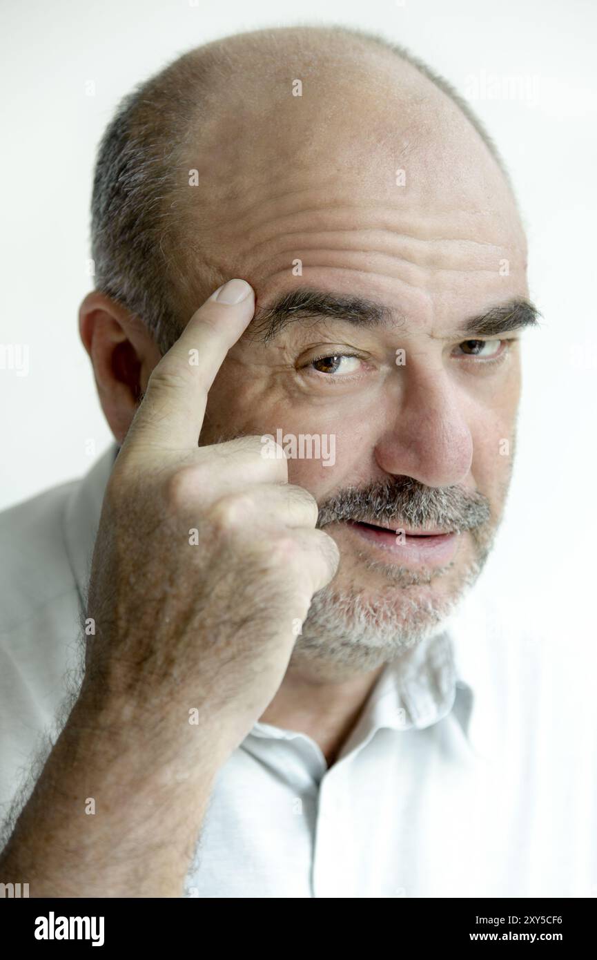 Man points to forehead with index finger Stock Photo - Alamy