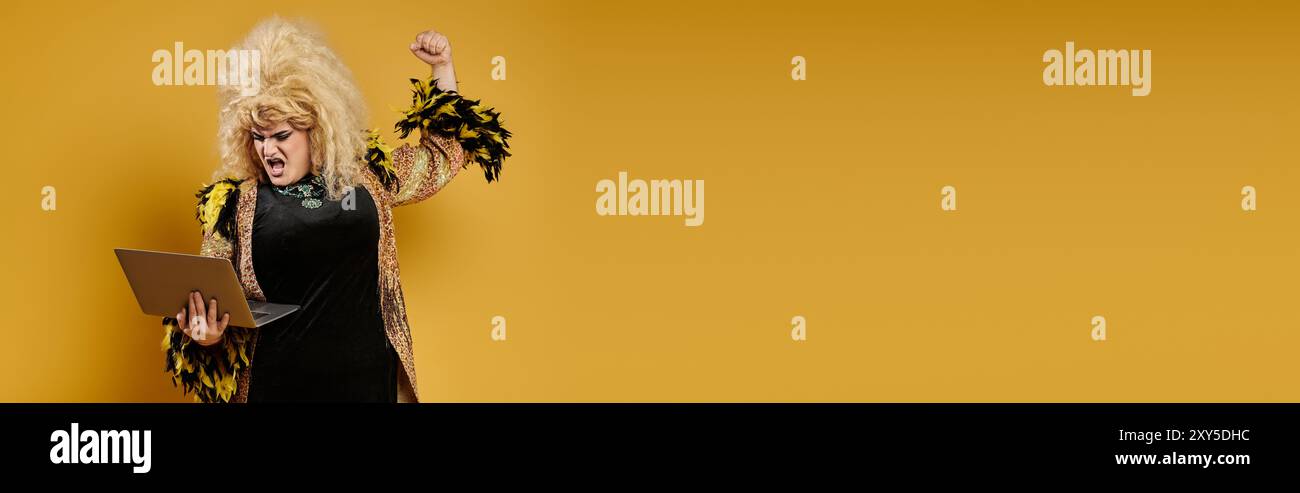 drag queen in colorful outfit raises fist in victory with laptop on ...