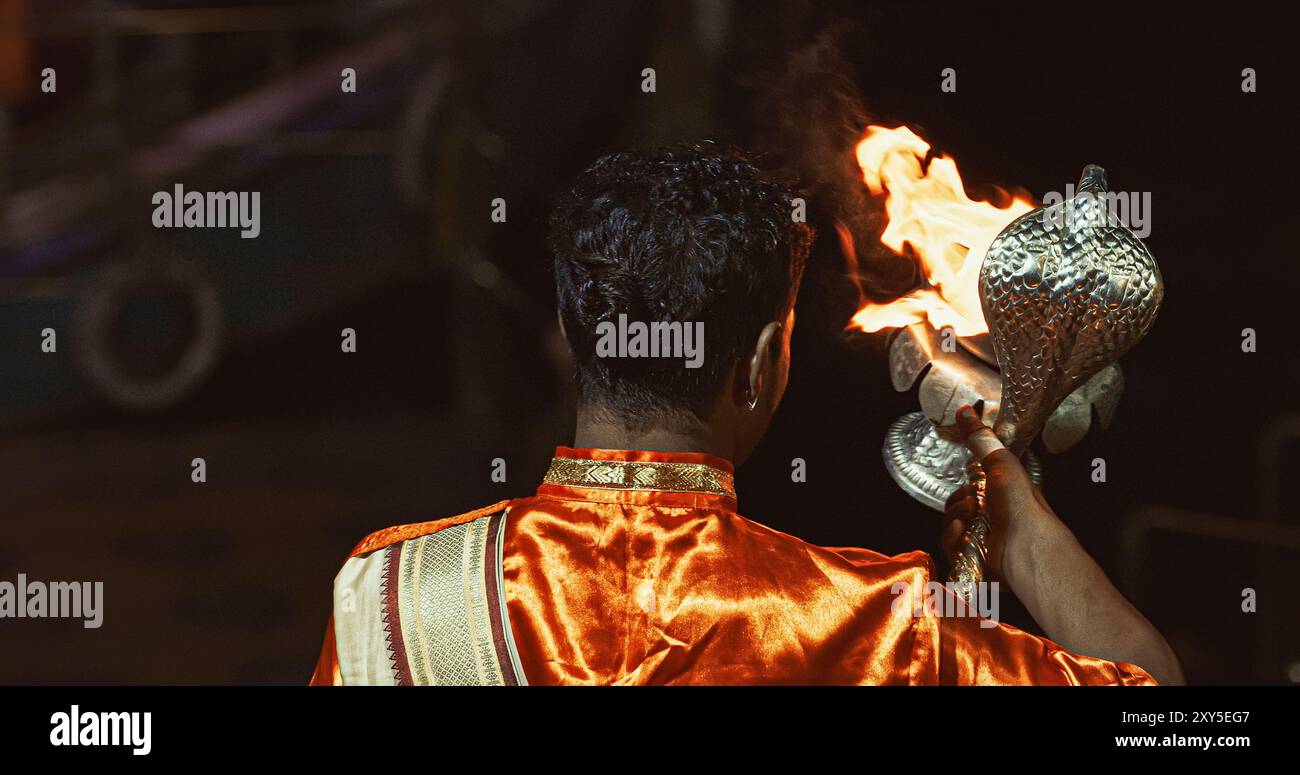 Varanasi, India. Man makes movements with a candle holder with lit ...