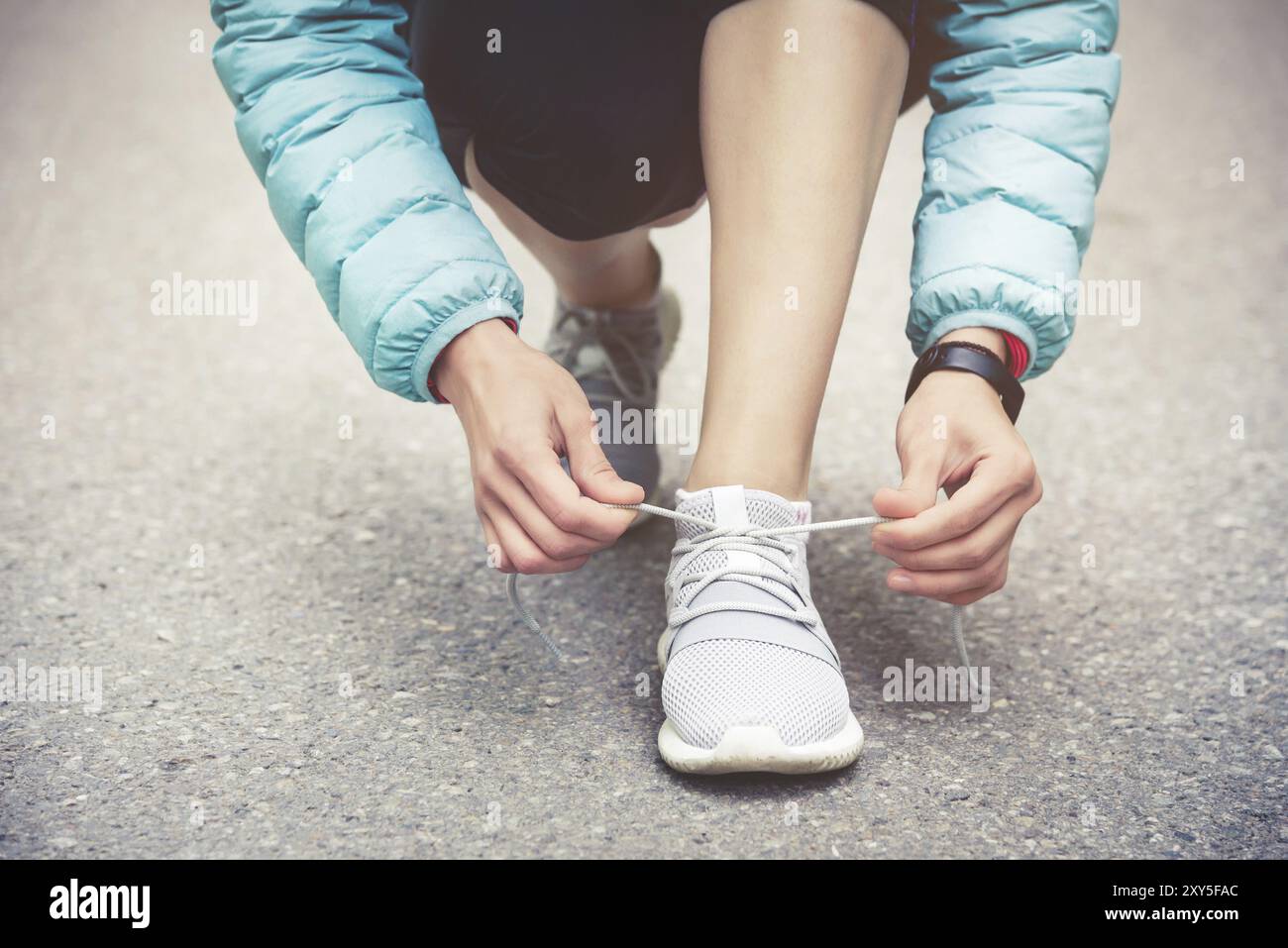 Girl runner tying laces for jogging her shoes on road in a park. Running shoes, Shoelaces ...