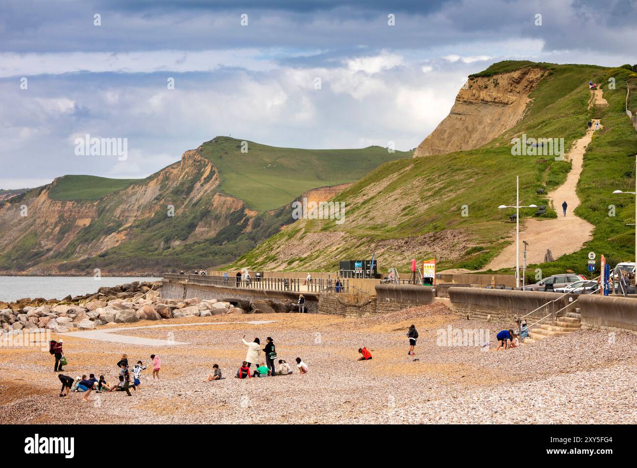 UK England, Dorset, Bridport, West Bay, visitors on beach below coast ...