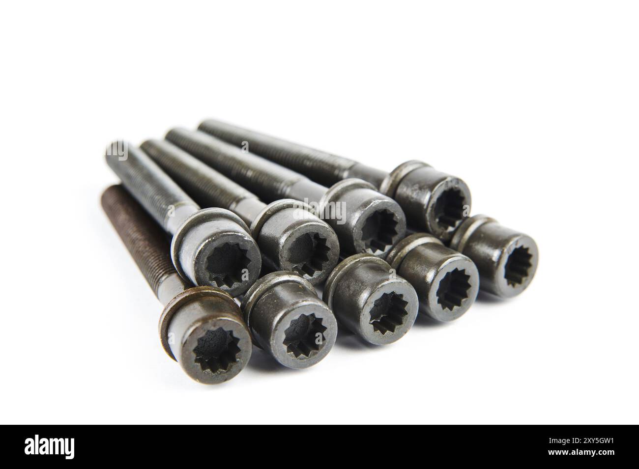 A set of new cylinder head bolts in oil on a white isolated background ...