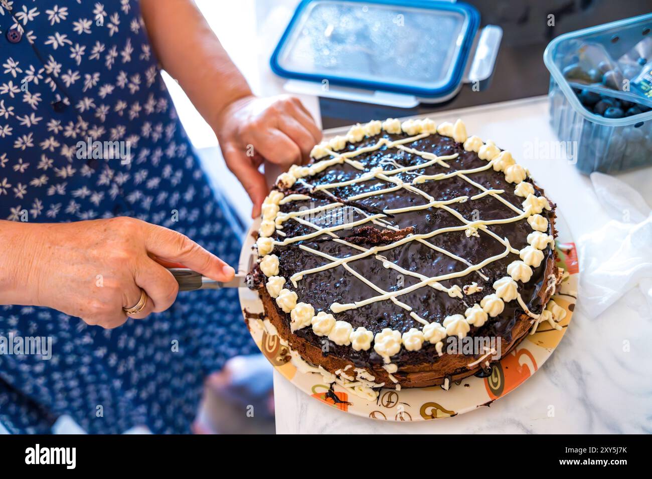 The process of close up cutting a homemade chocolate cake by senior ...