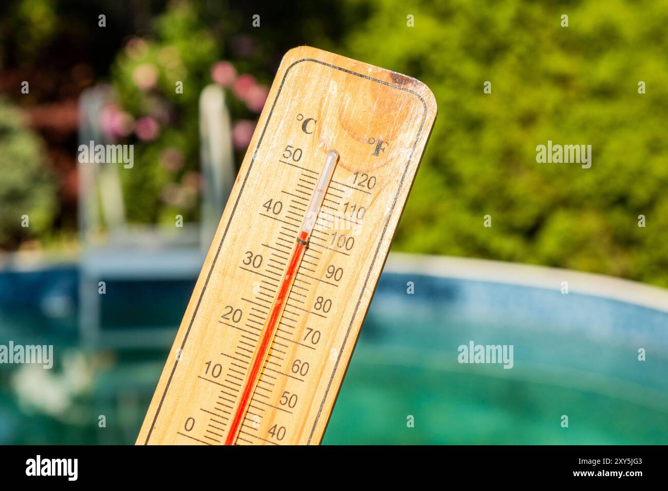 Thermometer displaying high summer temperature on a swimming pool ...