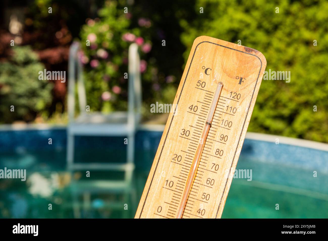 Thermometer showing almost 40 degrees celsius held above a swimming ...