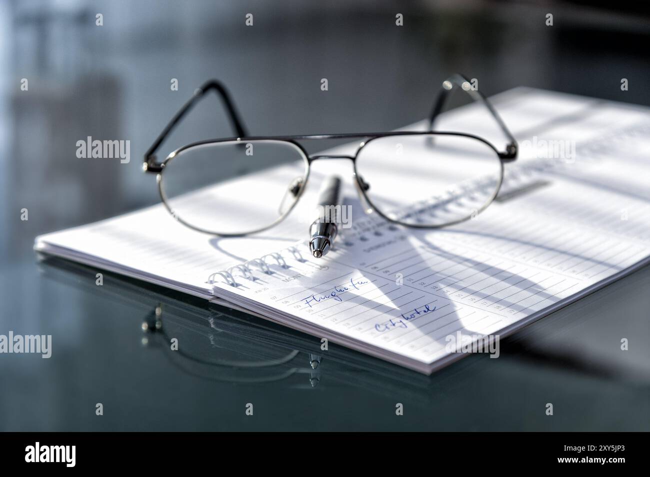 Open calendar with biros and glasses Stock Photo - Alamy
