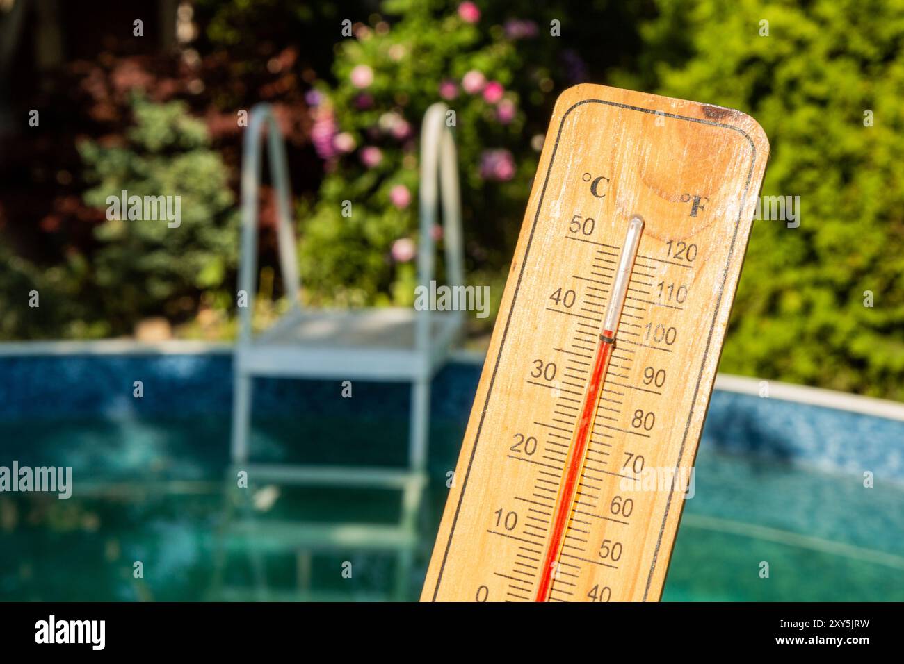 Thermometer displaying high summer temperature on a swimming pool ...