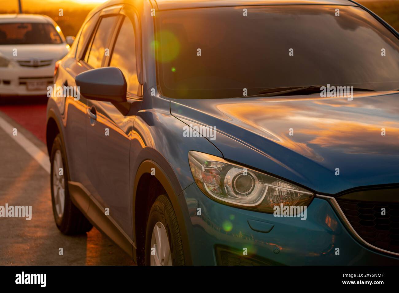 Luxury SUV with modern design parked on roadside at sunset. Front view ...