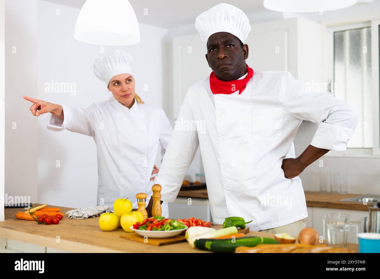 Chefs in white uniform having conflict on kitchen Stock Photo - Alamy