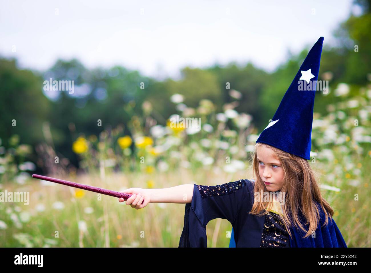 Caucasian blonde child girl in wizard blue costume with cape and hat ...