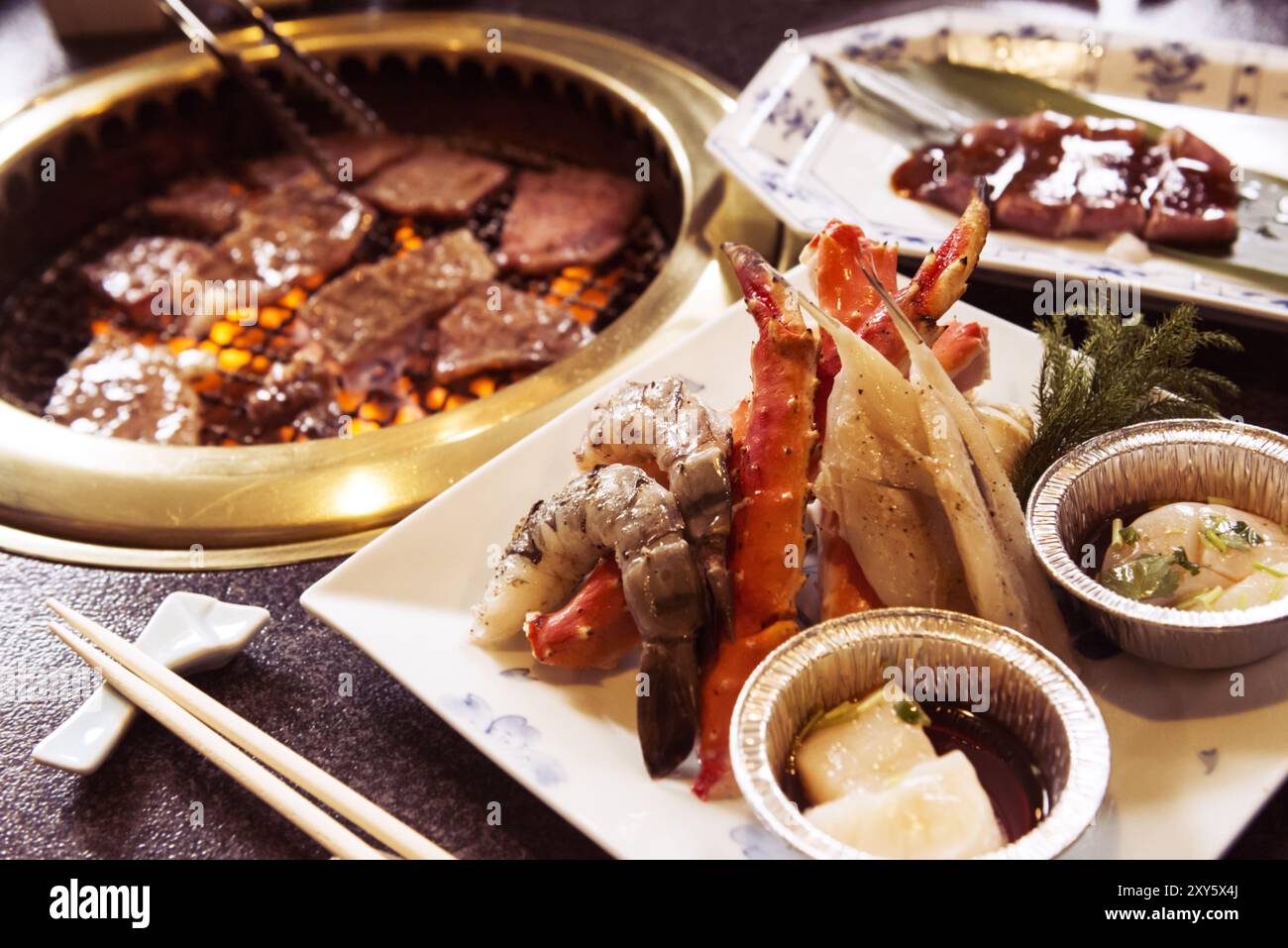Beef and seafood being cooked at a Japanese grill restaurant. Yakiniku ...
