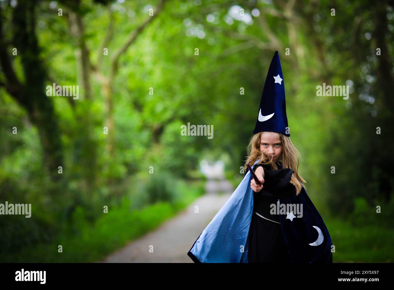 Caucasian blonde child girl in wizard blue costume with cape and hat ...