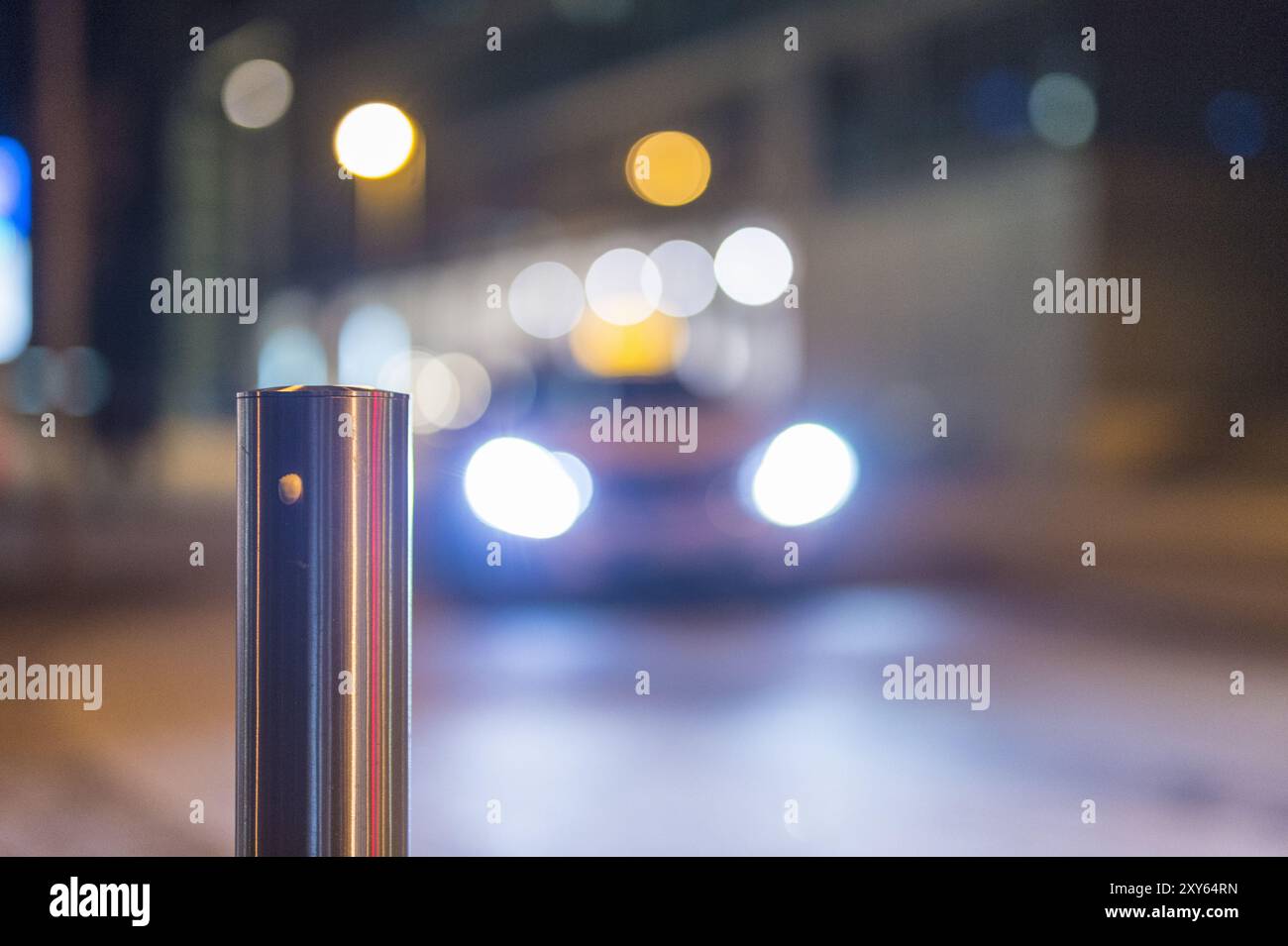 View over a bollard at the side of the road onto a moving car with its ...